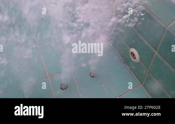 Close up, underwater, air bubbles from jacuzzi spa jet in swimming pool ...