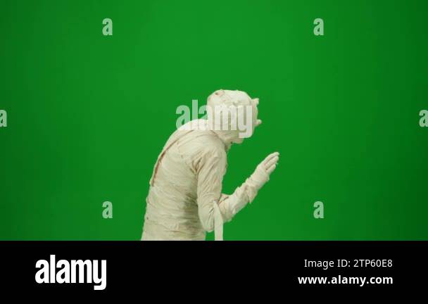 Scary mummy looks around, searches for a victim and scares with raised ...