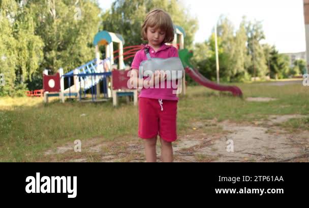 Sad child outdoors with a broken limb small, injured boy. The child has ...