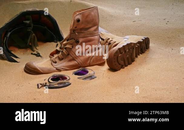 Parts of a soldier's uniform lay in the sand. Ruins after the war ...