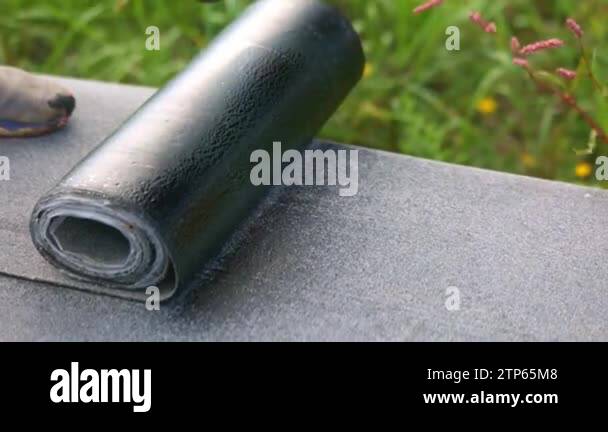 Process of melting a roll of tar onto the foundation of a house under ...