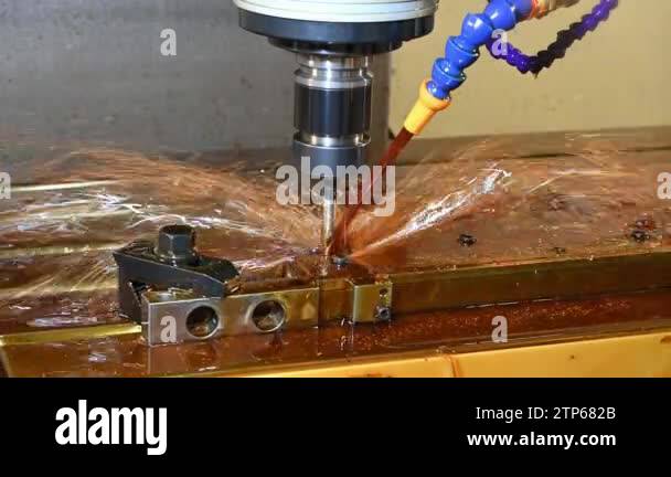 The CNC milling machine cutting the mold parts with oil coolant method ...