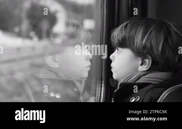 Monochromatic pensive child staring at landscape pass by from high ...