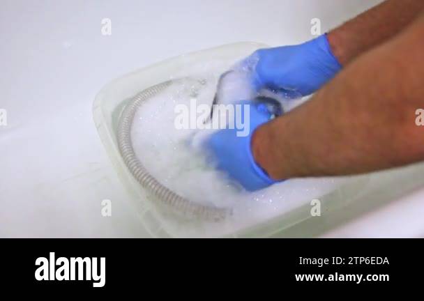 Man with blue gloves cleans cpap hoses and cpap mask as maintenance for ...