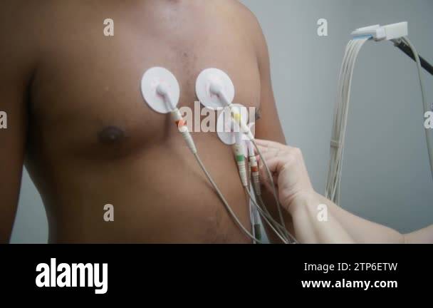 Female cardiologist puts sensors for holter monitoring on patient with ... Female cardiologist puts sensors for holter monitoring on patient with ...
