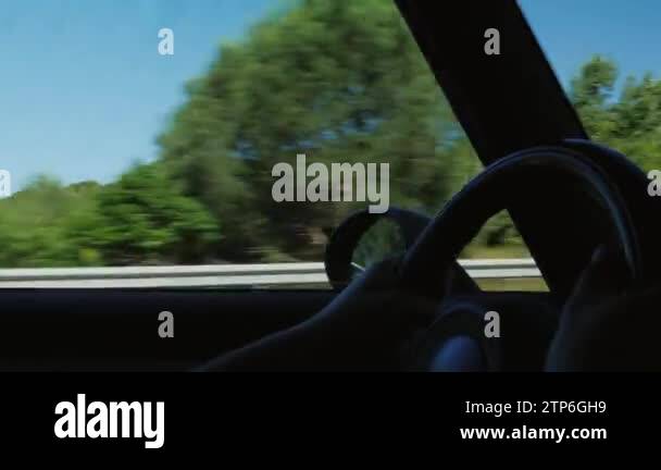 drivers hands on the steering wheel of a moving car. Cars driving on a ...