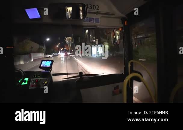 View from the windshield of a bus on the road in the night city of ...