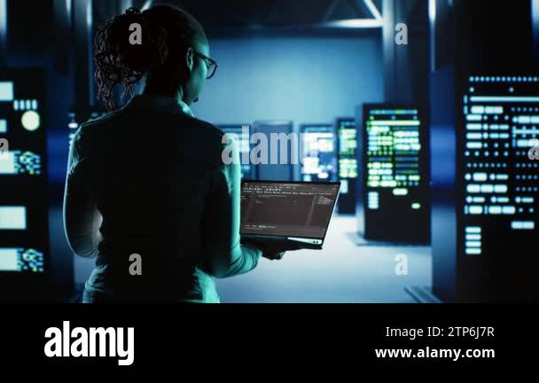 Engineer walking in server room housing advanced infrastructure storing ...