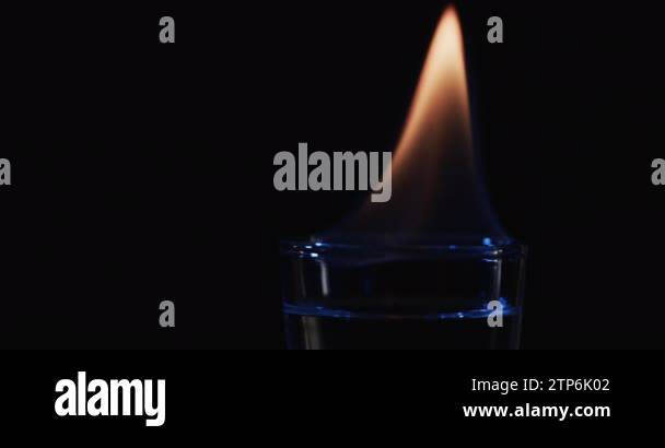 Video of lit alcohol in glass with orange fire flame and copy space on ...