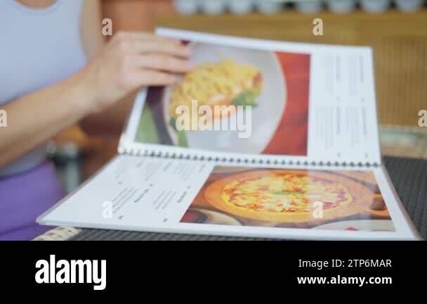 Woman reading restaurant menu close-up. Female hands holding menu in ...
