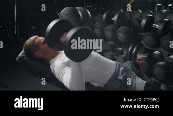 Young man bodybuilder with muscular body doing bench press with heavy ...