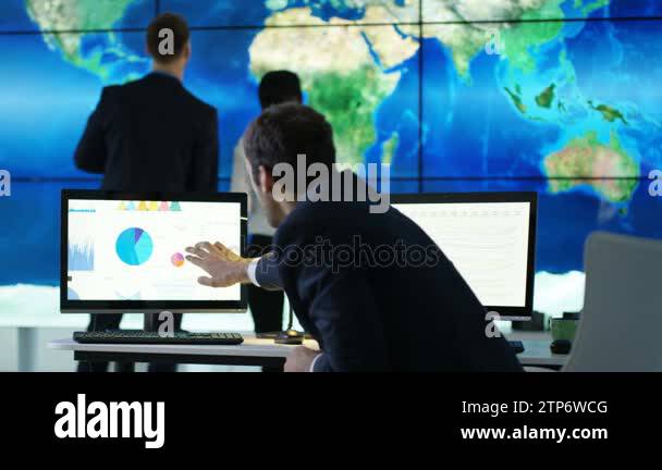 4K Business team discussing large world map graphic on video wall, with ...
