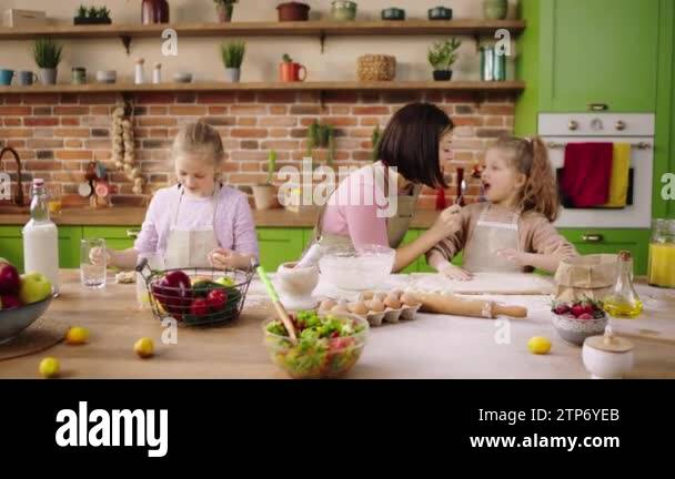 Singing with a tablespoon happy mother while preparing some delicious ...