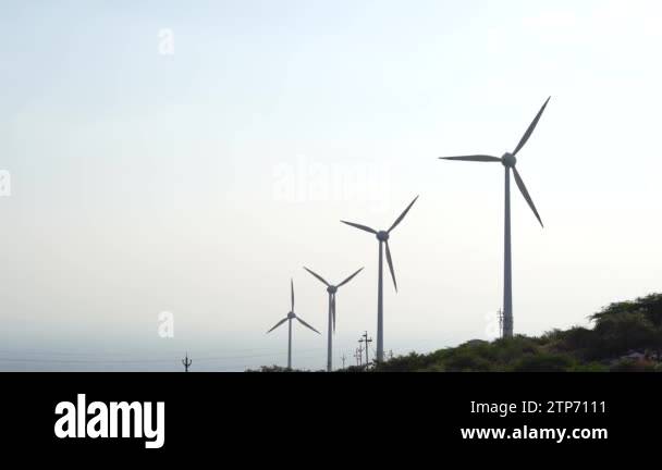 Footage of Wind turbines farm on the green grass field with clear blue ...