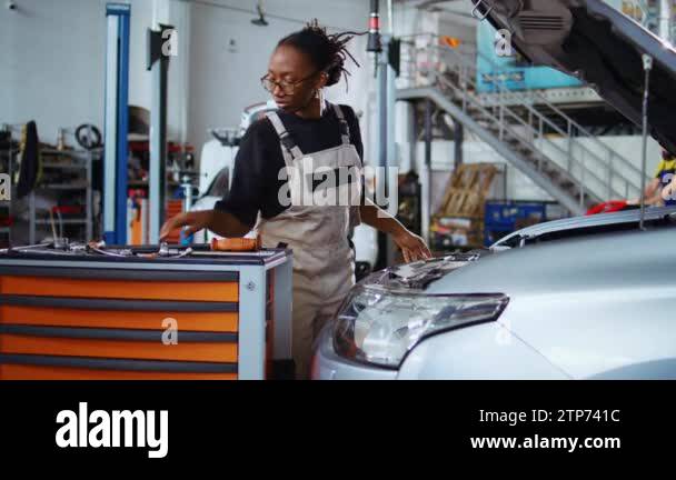Precise worker in repair shop using torque wrench to tighten screws ...