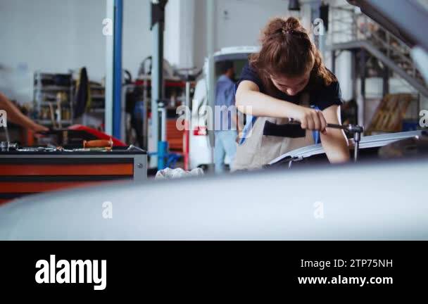 Precise worker in car service using torque wrench to tighten bolts ...