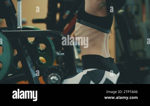 Pretty girl do exercise on back muscles in block simulator in fitness ...