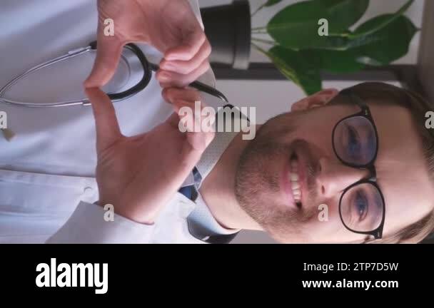 Portrait of a young positive doctor of European appearance standing in ...