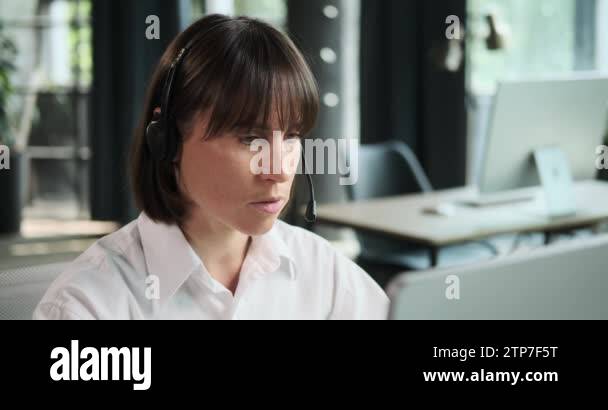 A dedicated female call center agent conducts a phone call with a ...