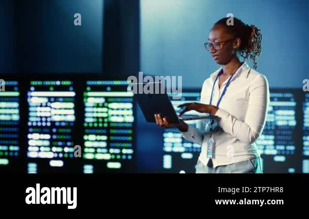 Computer scientist programming in server farm housing advanced equipment storing massive ...