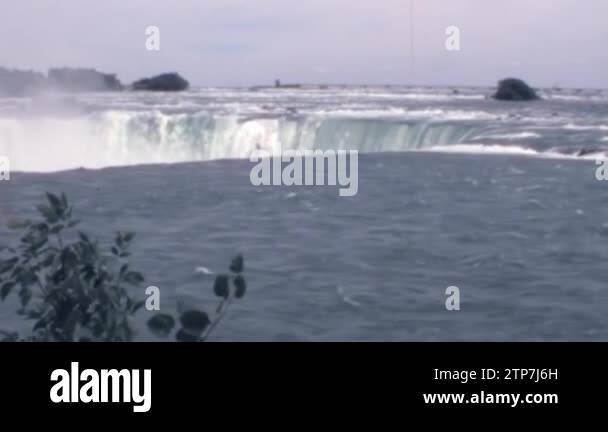 Impressive side view of Niagara Falls with large mass of water falling ...