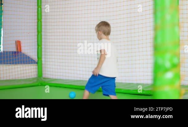 A child jumping on trampolines in an amusement park in a play center ...