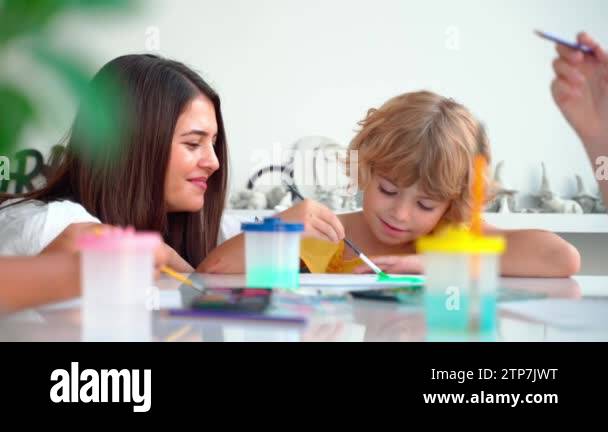 Teacher At Art School Helping Children in Art Class with painting ...