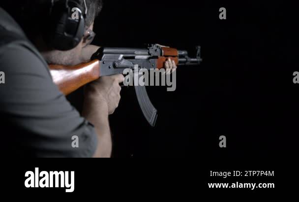 Shooting Kalashnikov weapon at highs-speed 800 fps slow-motion. Person ...