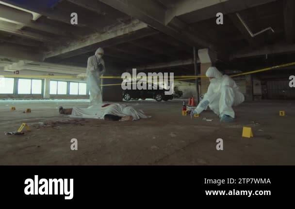 Full slowmo shot of two unrecognizable forensic investigators working ...