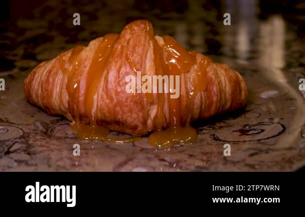 Fresh baked Croissant with liquid caramel inside cut in half isolated ...