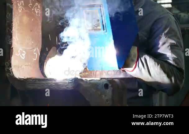Welding of Steel Profiles / Worker welder performs arc-welding process ...