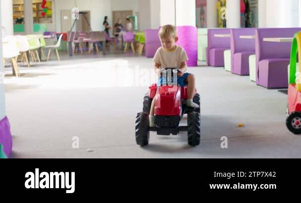 Boy driving a pedal car, child having fun riding a car in an amusement ...
