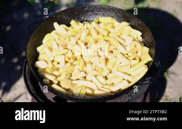 Man hand salting a dish. Cooking homemade fried potatoes frying pan in ...