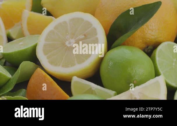 Ripe citruses fruits with slices and citrus leaves slowly move in the ...
