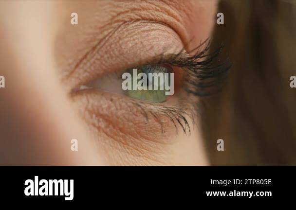 Side view of young woman with incredible light green eyes. Close up shot of eye opening with ...