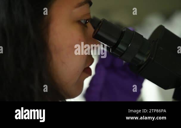 Close up of a female research scientist eyes, looking at samples under ...