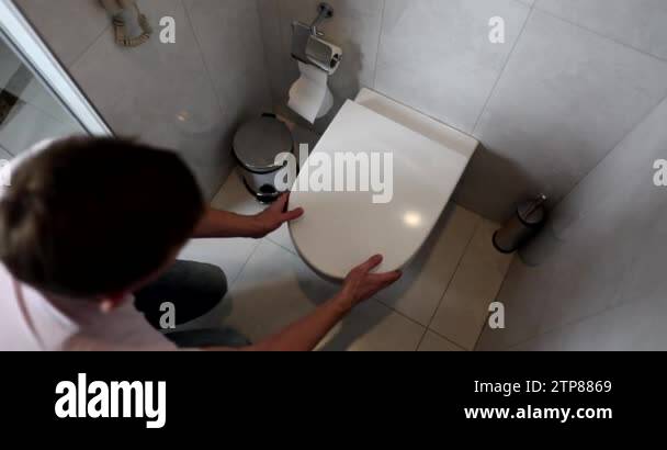 Man on his knees in bathroom vomits into toilet. Food poisoning food ...
