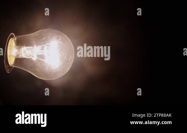 One Glowing Incandescent Light Bulb in Thick Smoke on Black Background ...