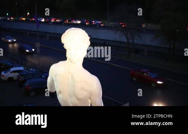 Plaster copy of statue of David by Michelangelo and cars go on road at ...