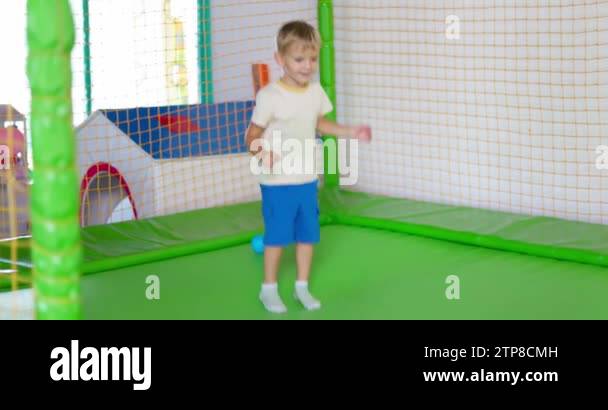 A child jumping on trampolines in an amusement park in a play center ...