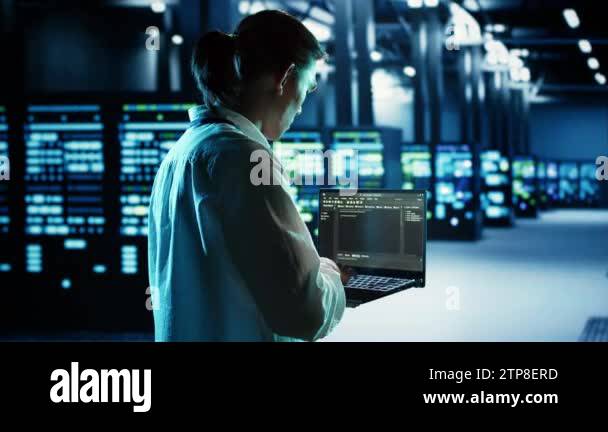 Qualified IT developer running code on laptop, troubleshooting and upgrading data center ...