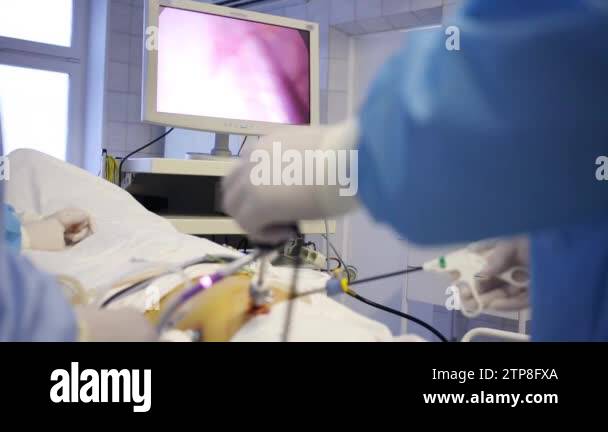 Display showing endoscopic surgery in abdominal organ and hands of ...