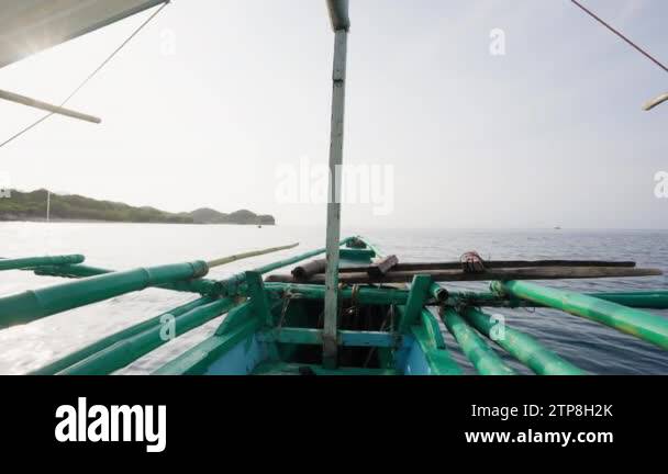 A traditional Filipino boat gracefully sailing across the vast expanse ...
