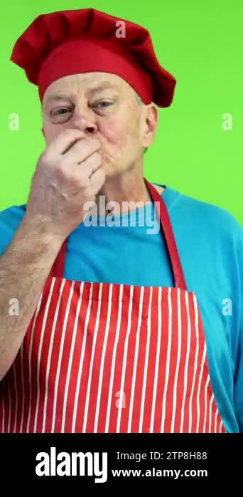 Senior cook in apron makes delicious, perfect gesture and shows thumbs ...