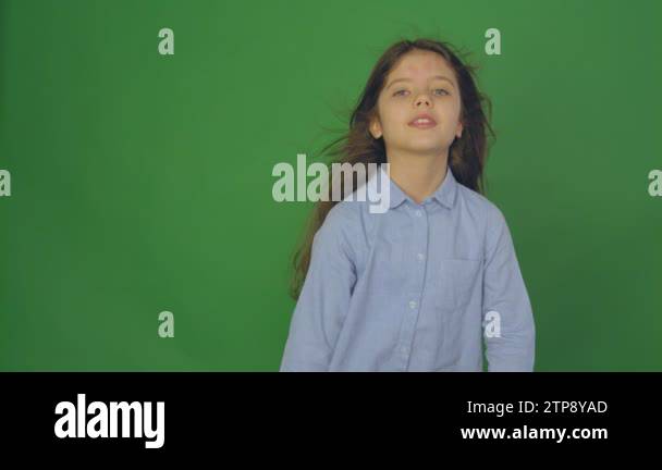 Positive beautiful girl talking to a camera with a smile on a Green ...