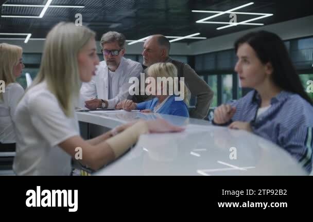 Adult woman stands near reception desk in clinic lobby area and makes ...