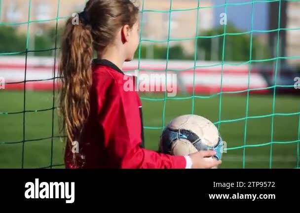 Girl throws and catches a ball and watching at football field Stock ...