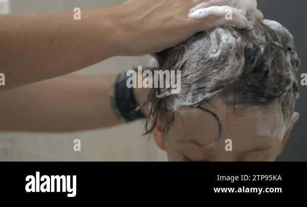 Parent hand washing child's hair with shampoo in slow-motion 800 fps ...
