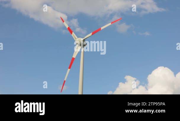 Wind turbine in a green field against a blue sky with clouds. Wind ...