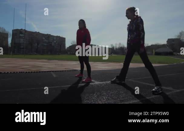 Young girls spend training exercises before the race. leg muscle warm ...